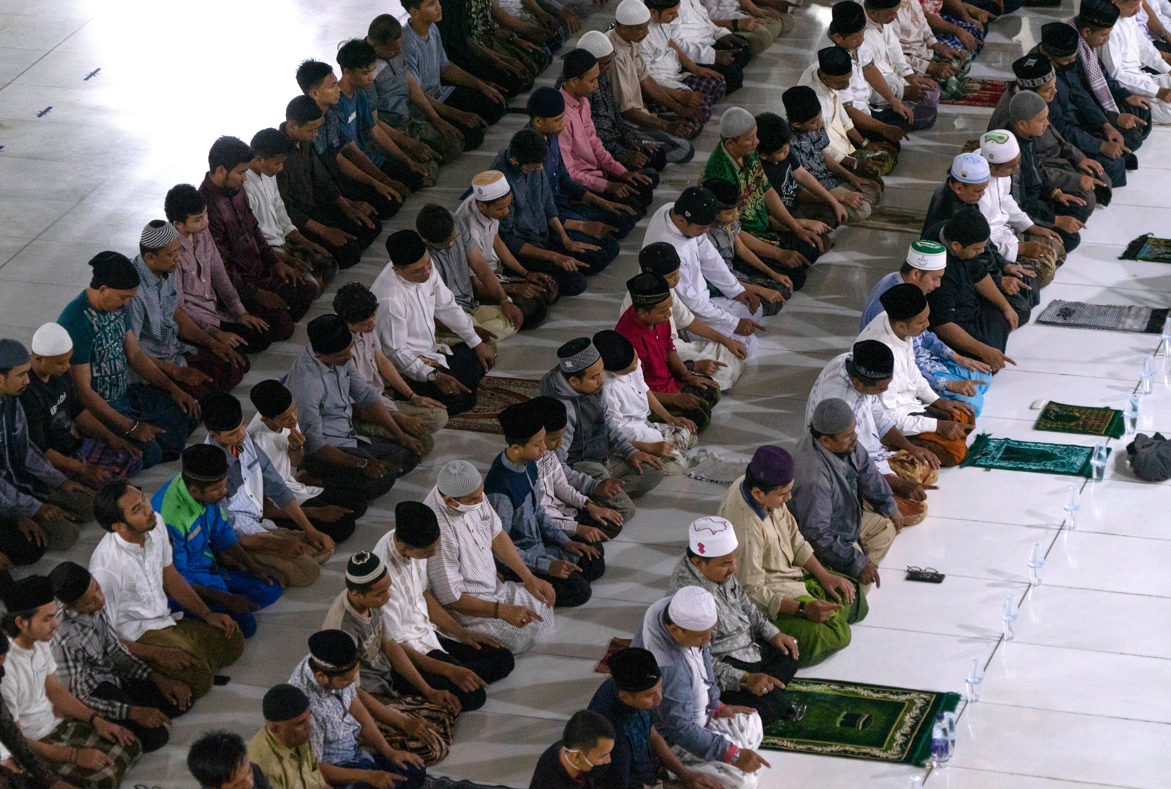 In Aceh, Indonesians pray at mosque but bring their own rugs